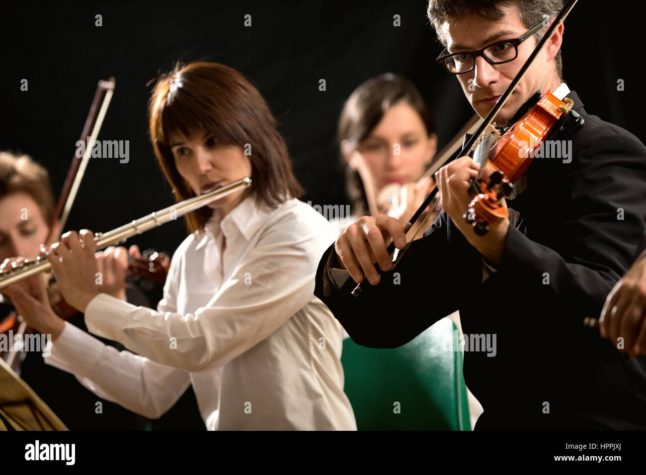 Female flutist and violinist performing in classical music concert ...