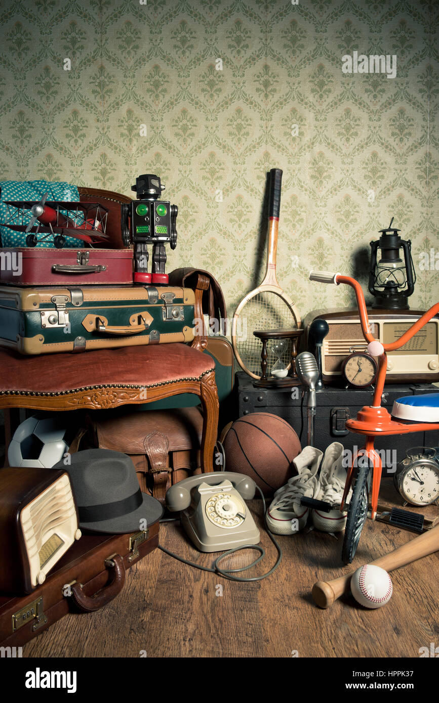 Assorted vintage items in the attic with retro wallpaper background ...