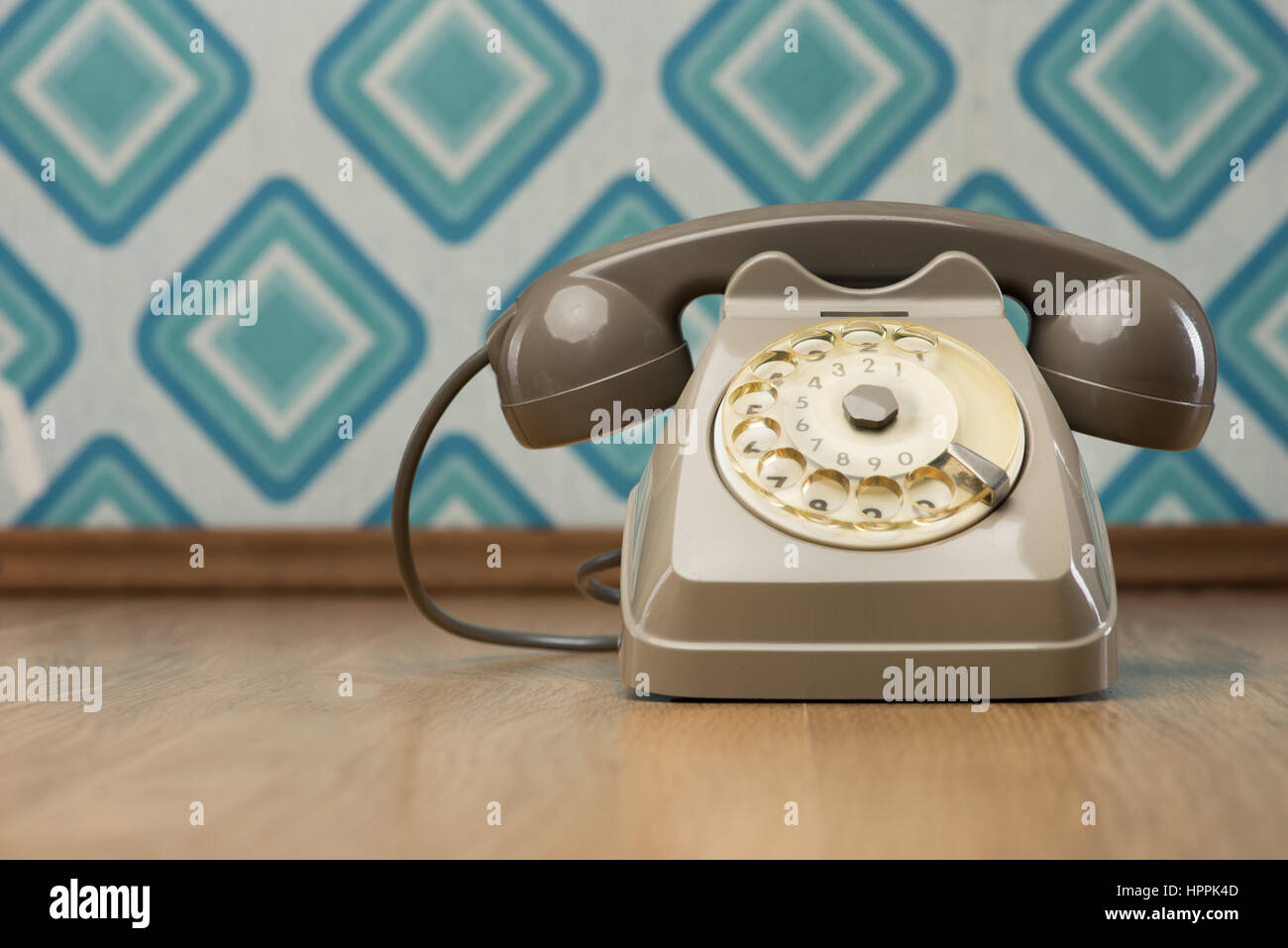 Vintage gray telephone on hardwood floor, diamond light blue retro ...