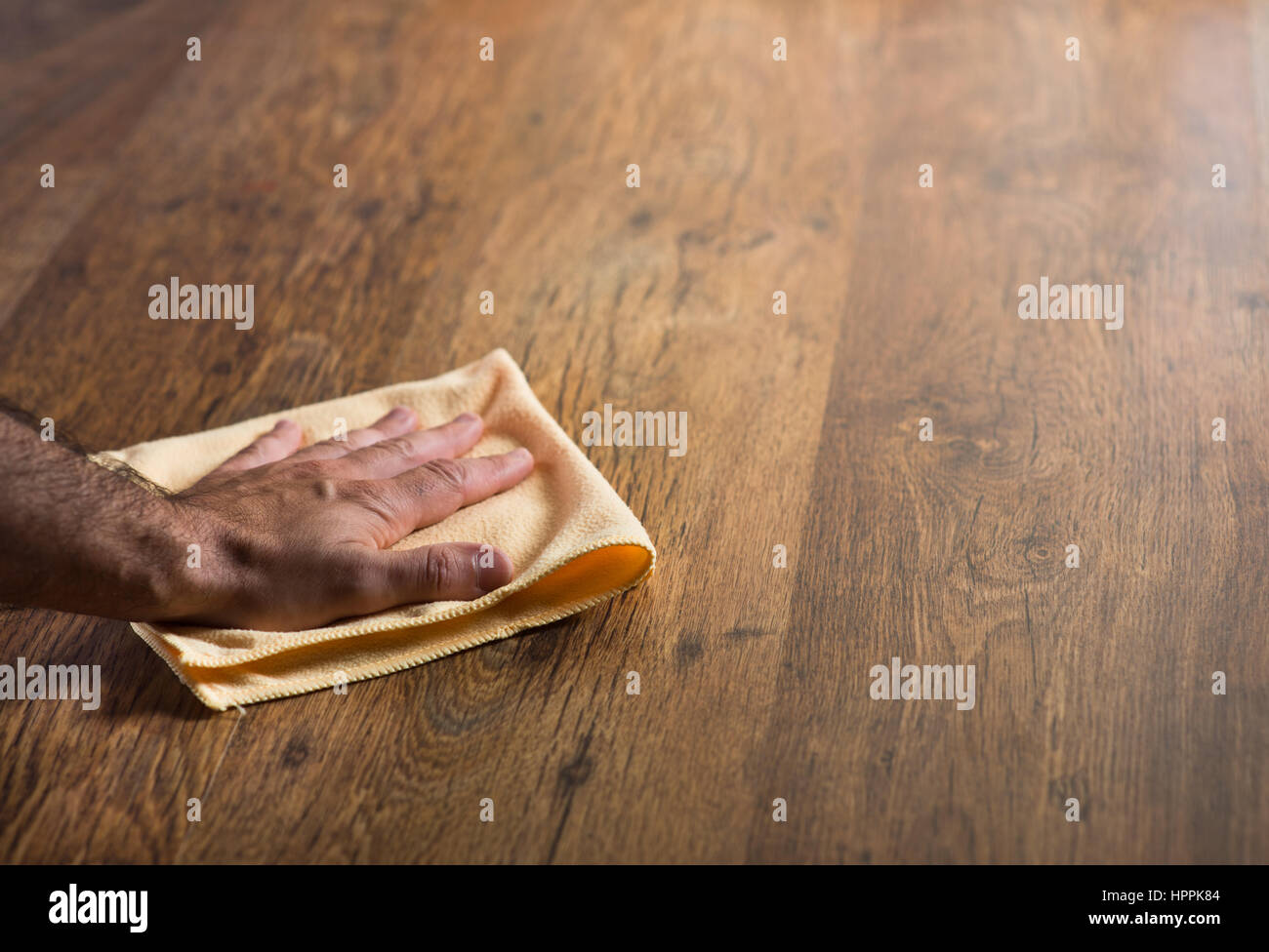 Male hand cleaning and rubbing an hardwood floor with a microfiber ...