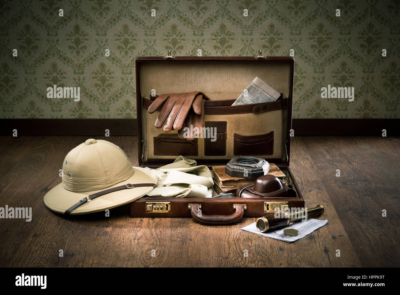Colonial style explorer packing with open leather briefcase, pith hat ...