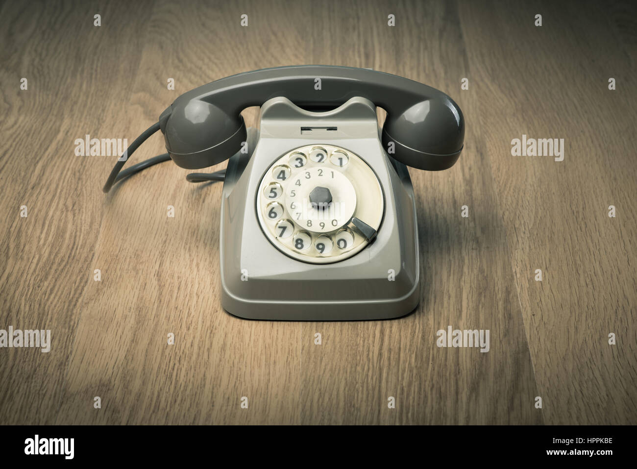Vintage gray telephone on hardwood surface desk or floor Stock Photo ...
