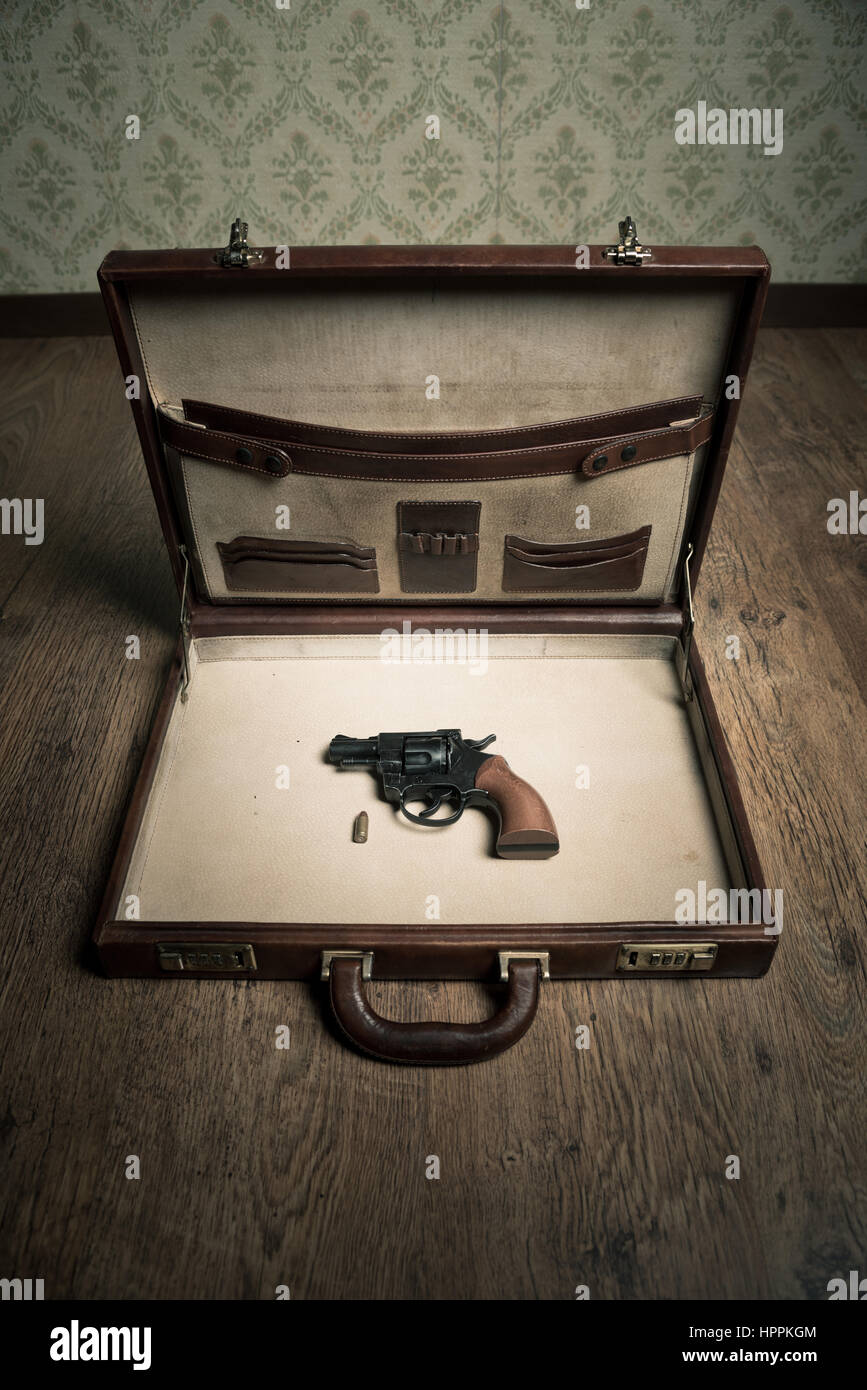 Open vintage leather briefcase with only revolver gun and bullet inside ...