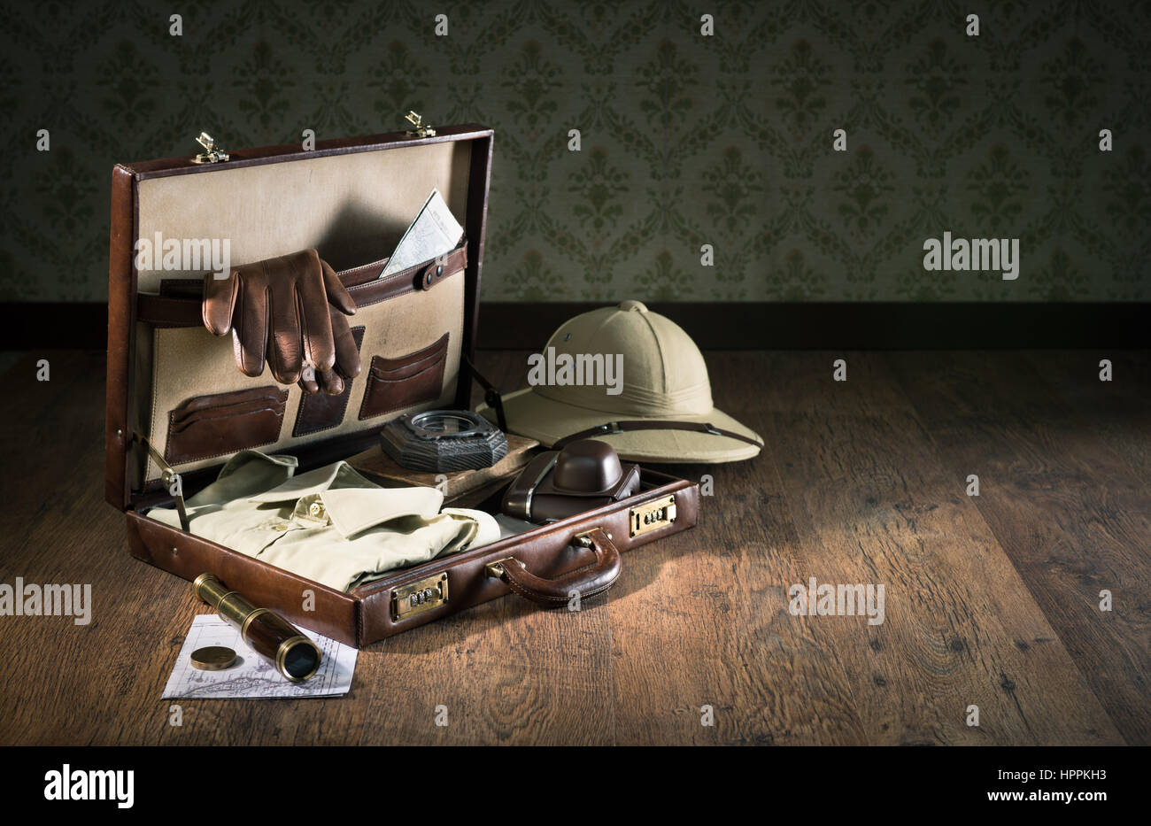Colonial style explorer packing with open leather briefcase, pith hat ...
