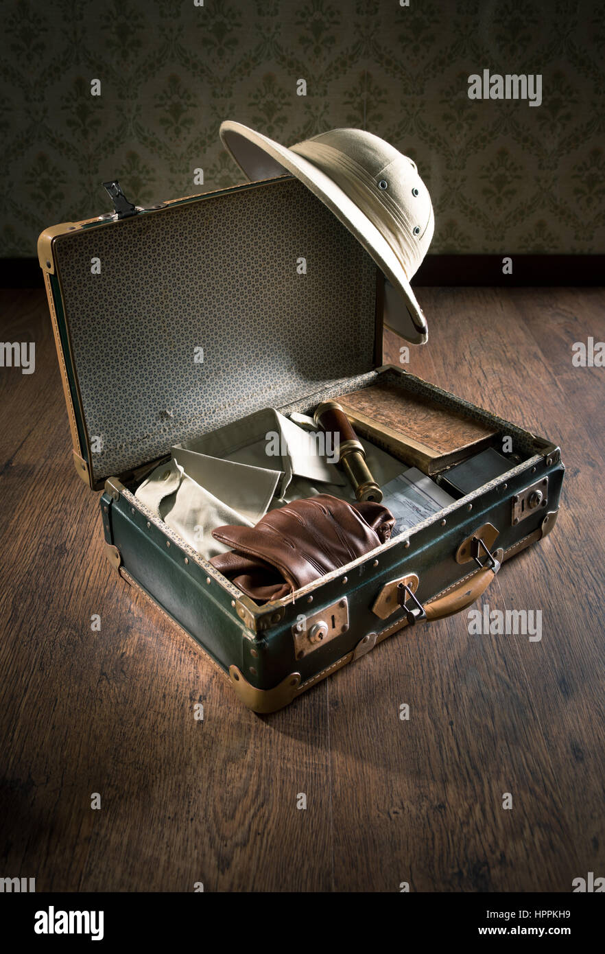 Open suitcase with colonial style explorer equipment including pith ...