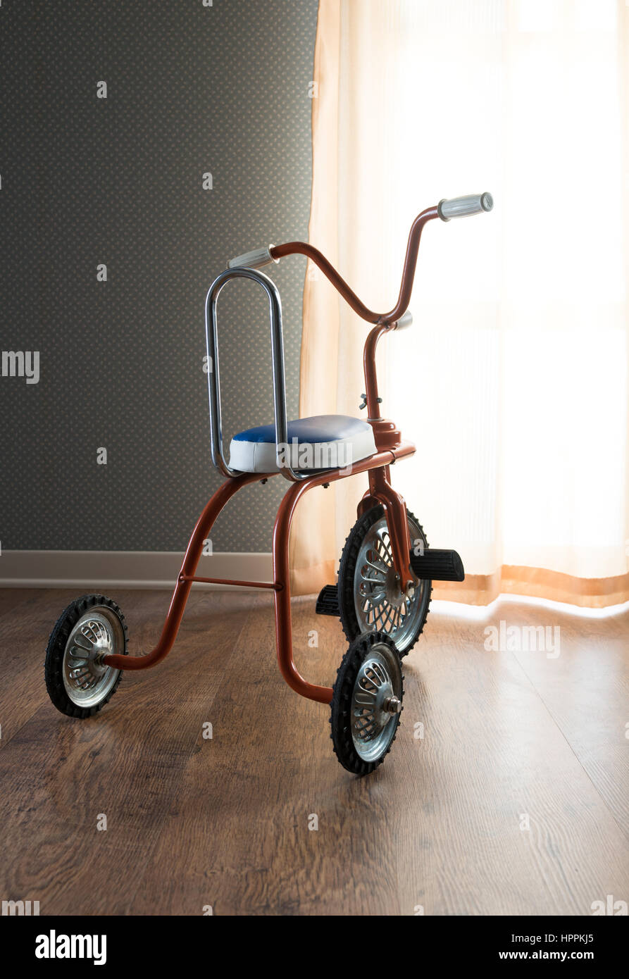 Vintage colorful tricycle next to a room window with curtain Stock ...