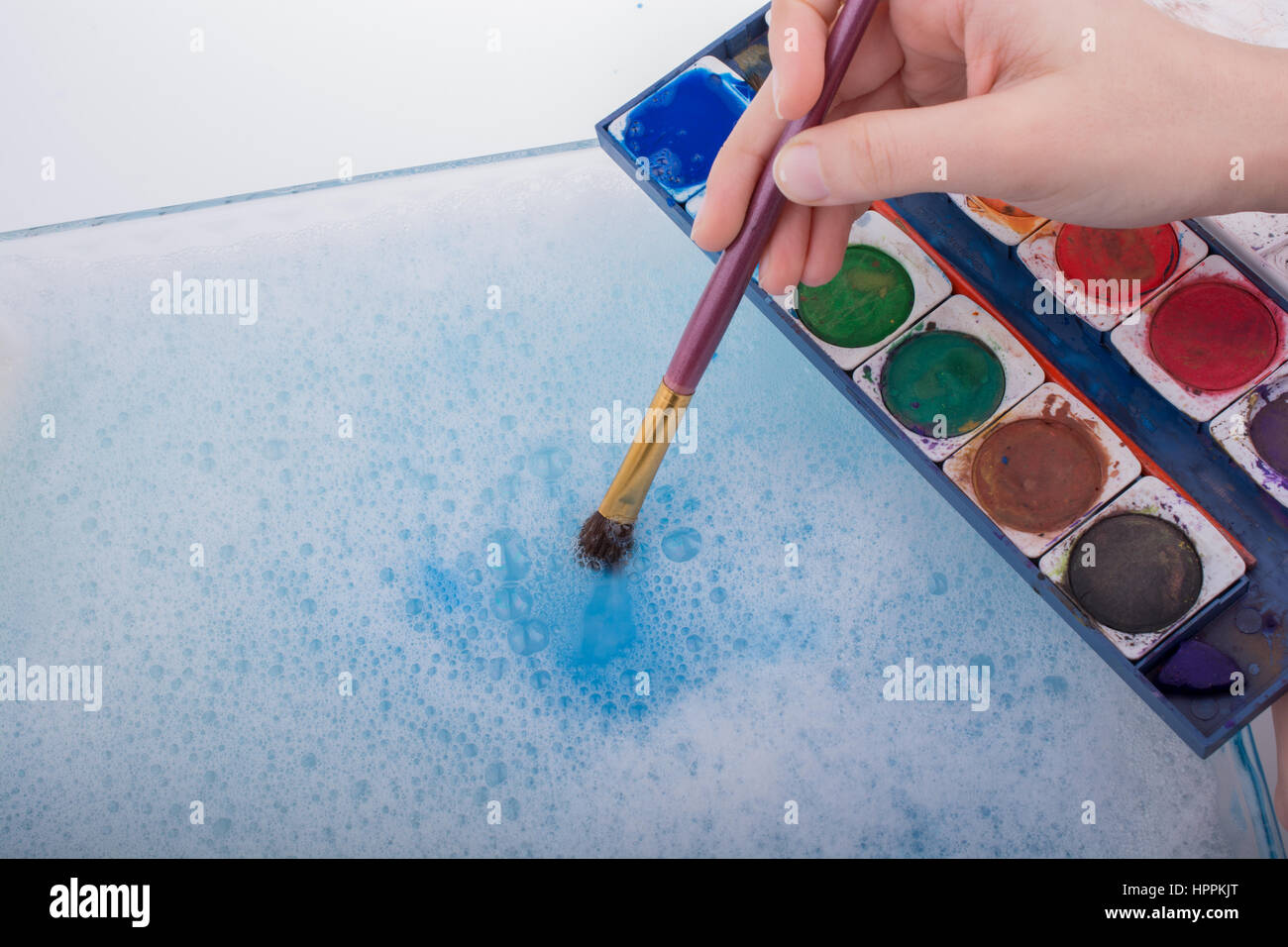 Watercolor paint dissolving in water covered with foam Stock Photo - Alamy
