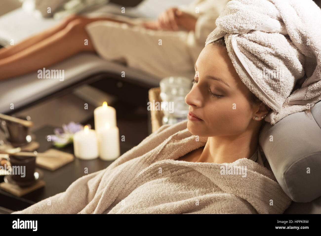 Beautiful woman enjoying spa treatments with candles on background ...