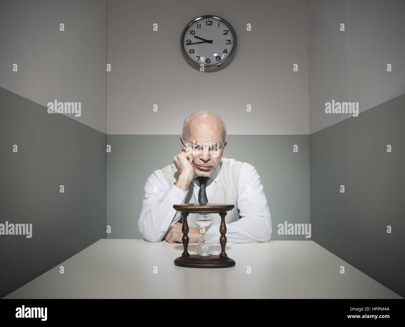 Bored vintage businessman waiting at desk with hourglass Stock Photo ...