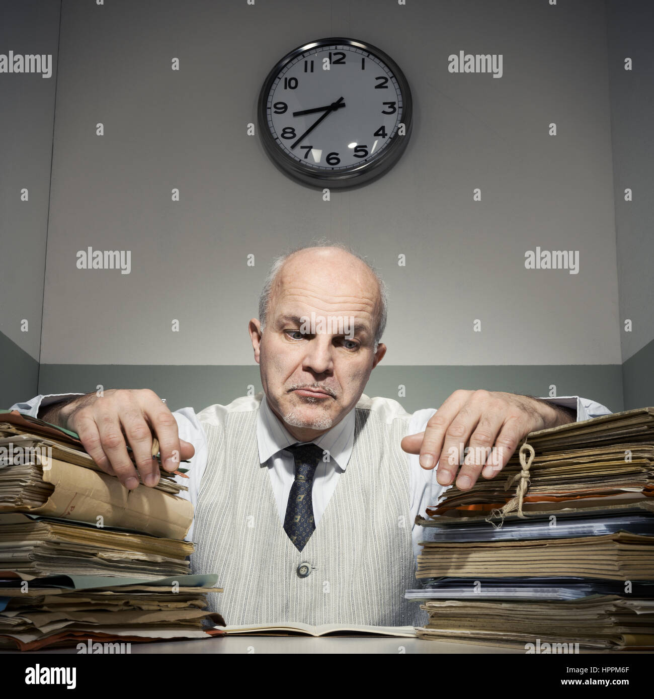 Overworked sad businessman with piles of folders Stock Photo - Alamy