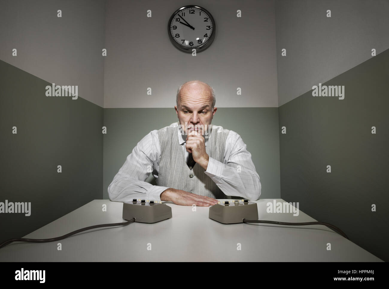 Confused office worker at his desk with intercoms Stock Photo - Alamy