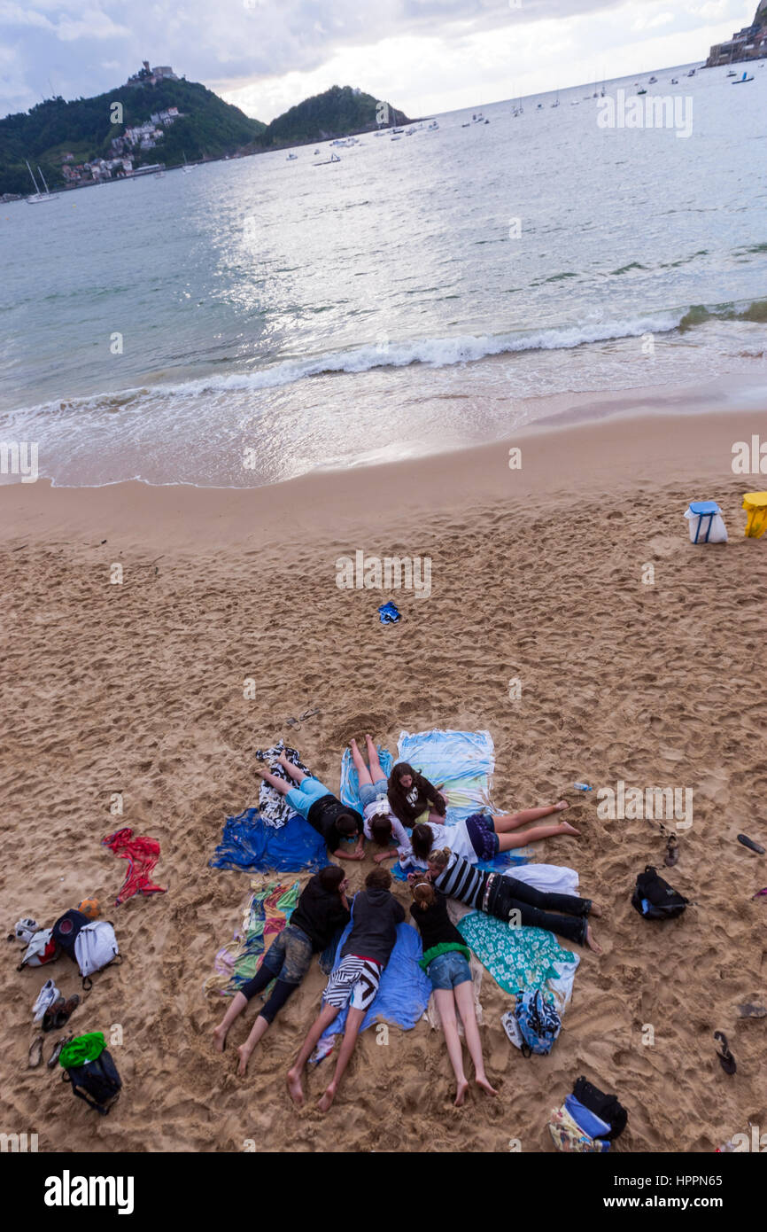 Group of young people lying on the Beach of La Concha, San Sebastian ...