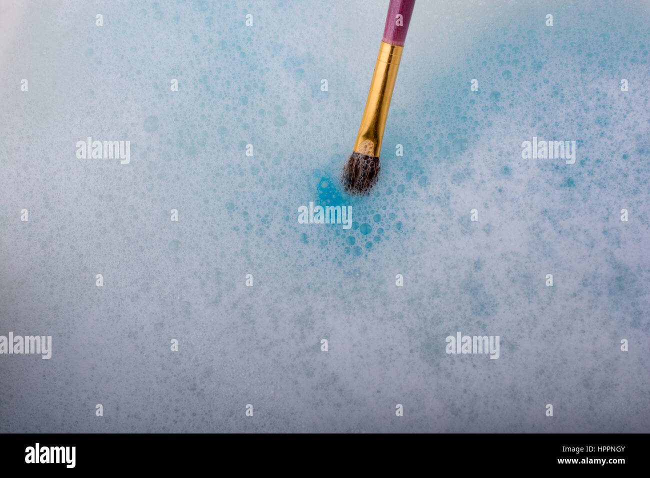 Paint dissolving in water as painting brush touching water Stock Photo ...