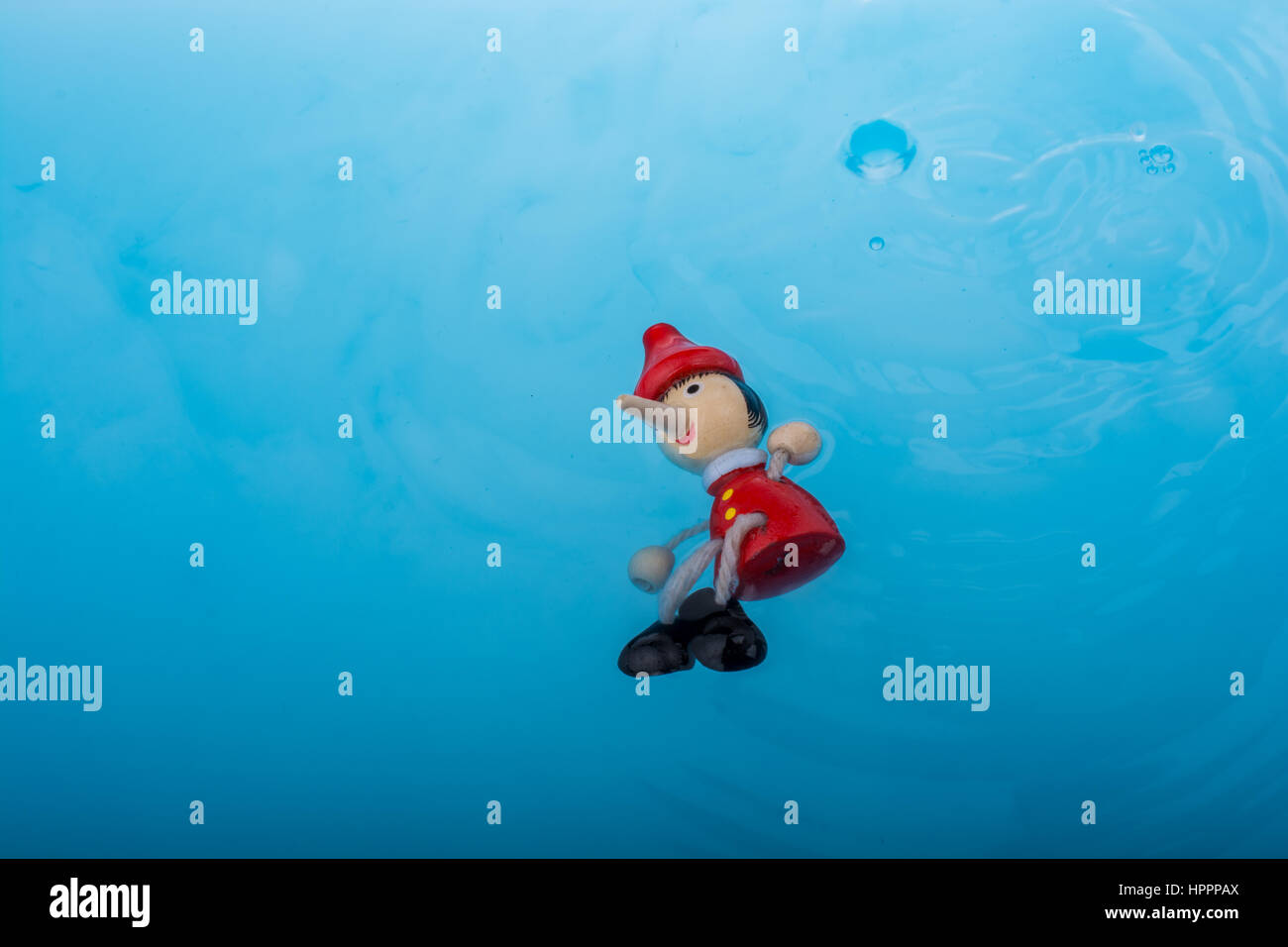 Wodden puppet Pinocchio on in blue water Stock Photo - Alamy
