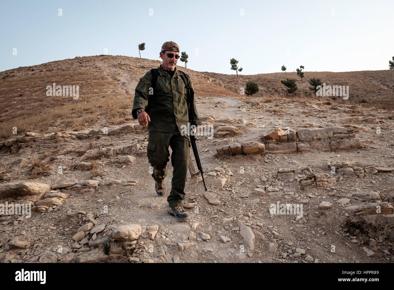 Harry Martinez and a Yazidi fighter make thier way down a hill from a ...