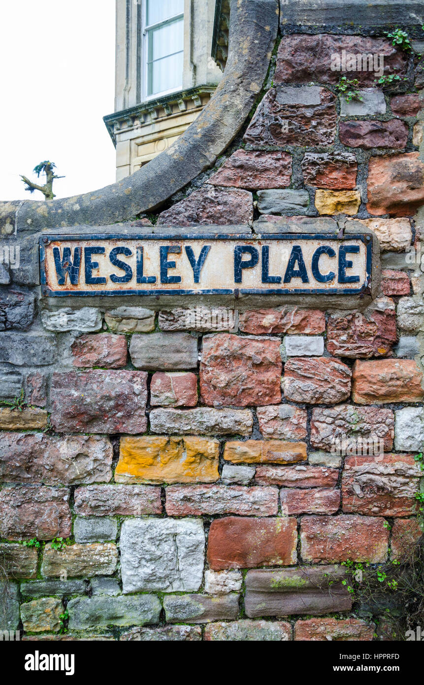 A street name sign for 'Wesley Place' in Bristol on an attractive stone ...