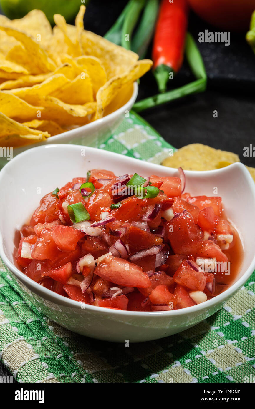 Bowl of fresh salsa with tortilla chips on a table Stock Photo - Alamy