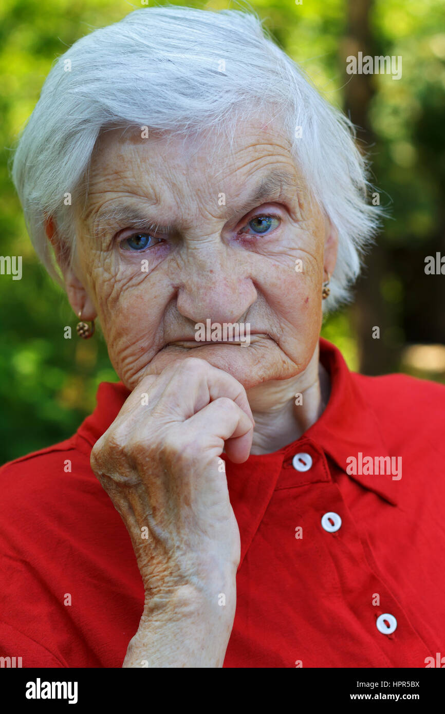 Distressed wrinkled elderly woman relaxing in the garden Stock Photo ...