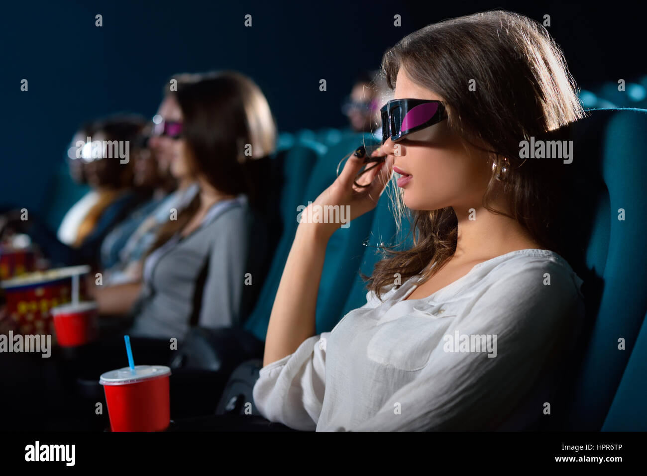All eyes on screen. Closeup portrait of a young female watching a movie ...
