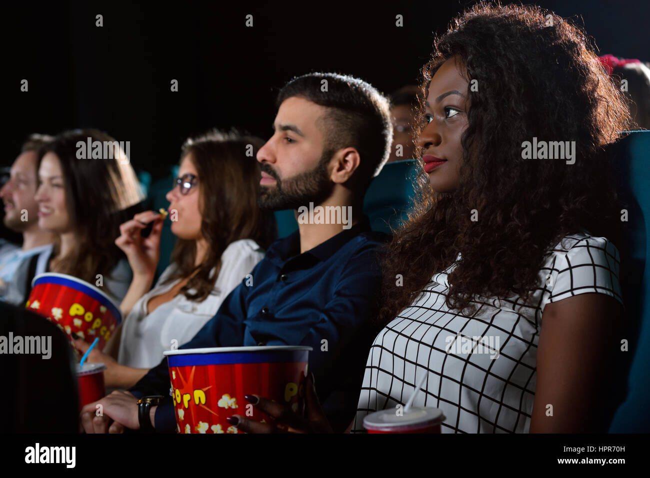Friday nights. Group of multicultural friends enjoying a movie together ...
