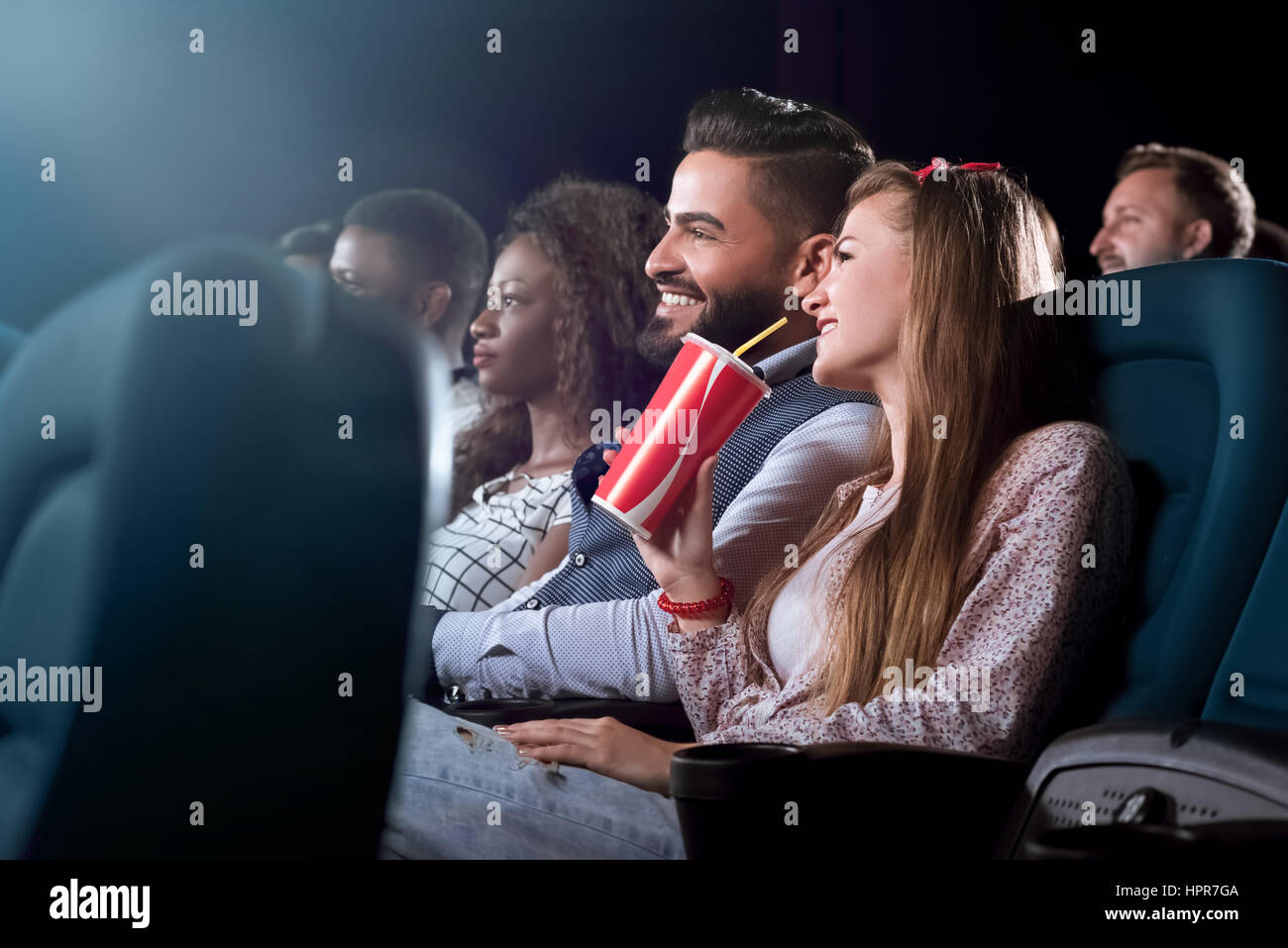 This movie is a hit Shot of a beautiful female holding her coke smiling ...