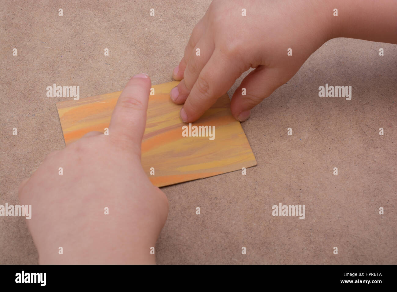 Hand holding painted note paper on brown background Stock Photo - Alamy