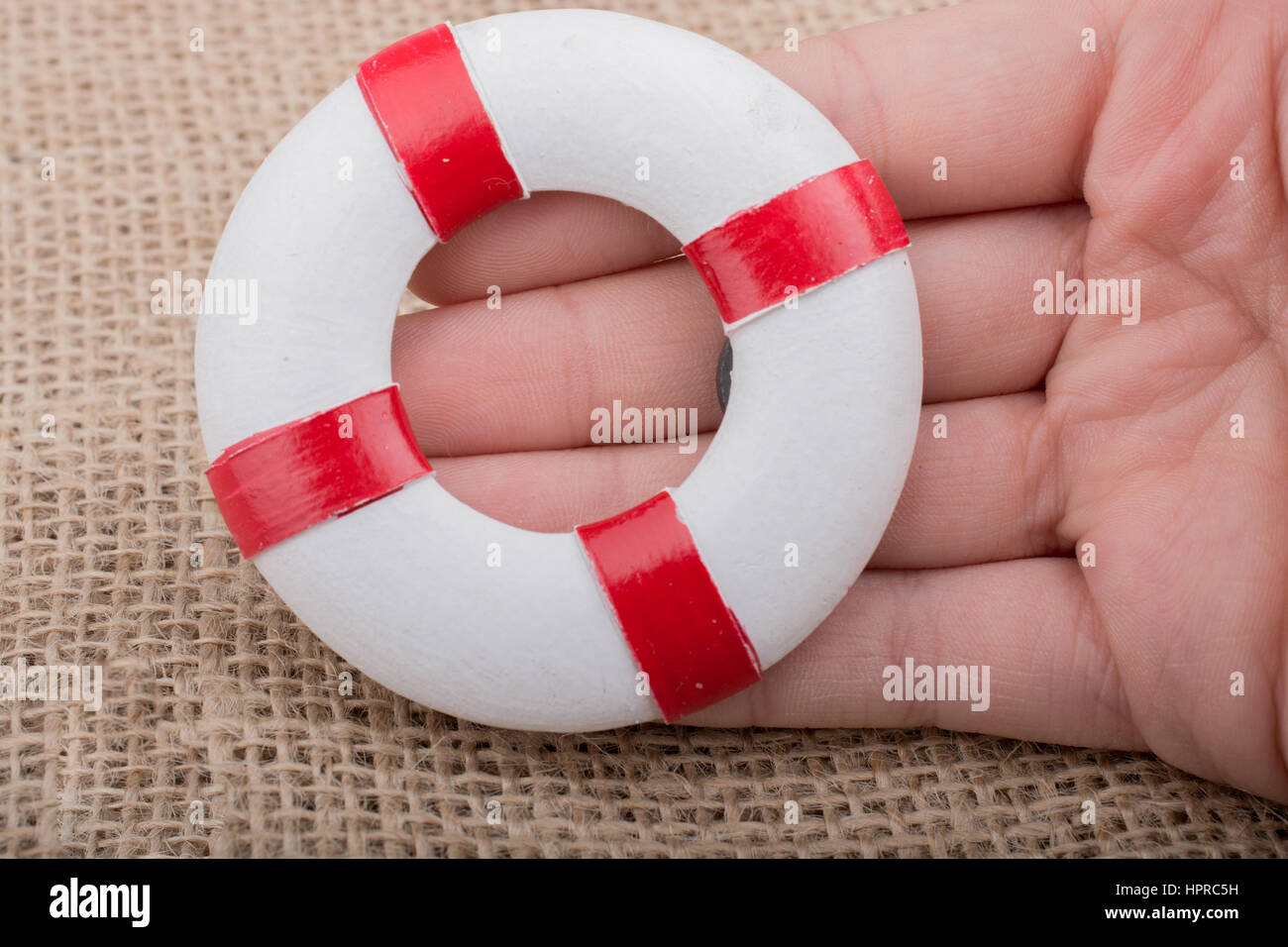 Hand holding a Lifesaver or life preserver on a fabric background Stock ...