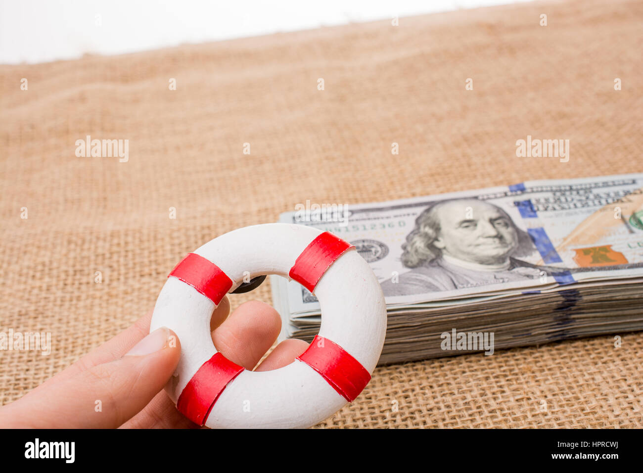 Life preserver in hand over the banknote bundle of US dollar Stock ...