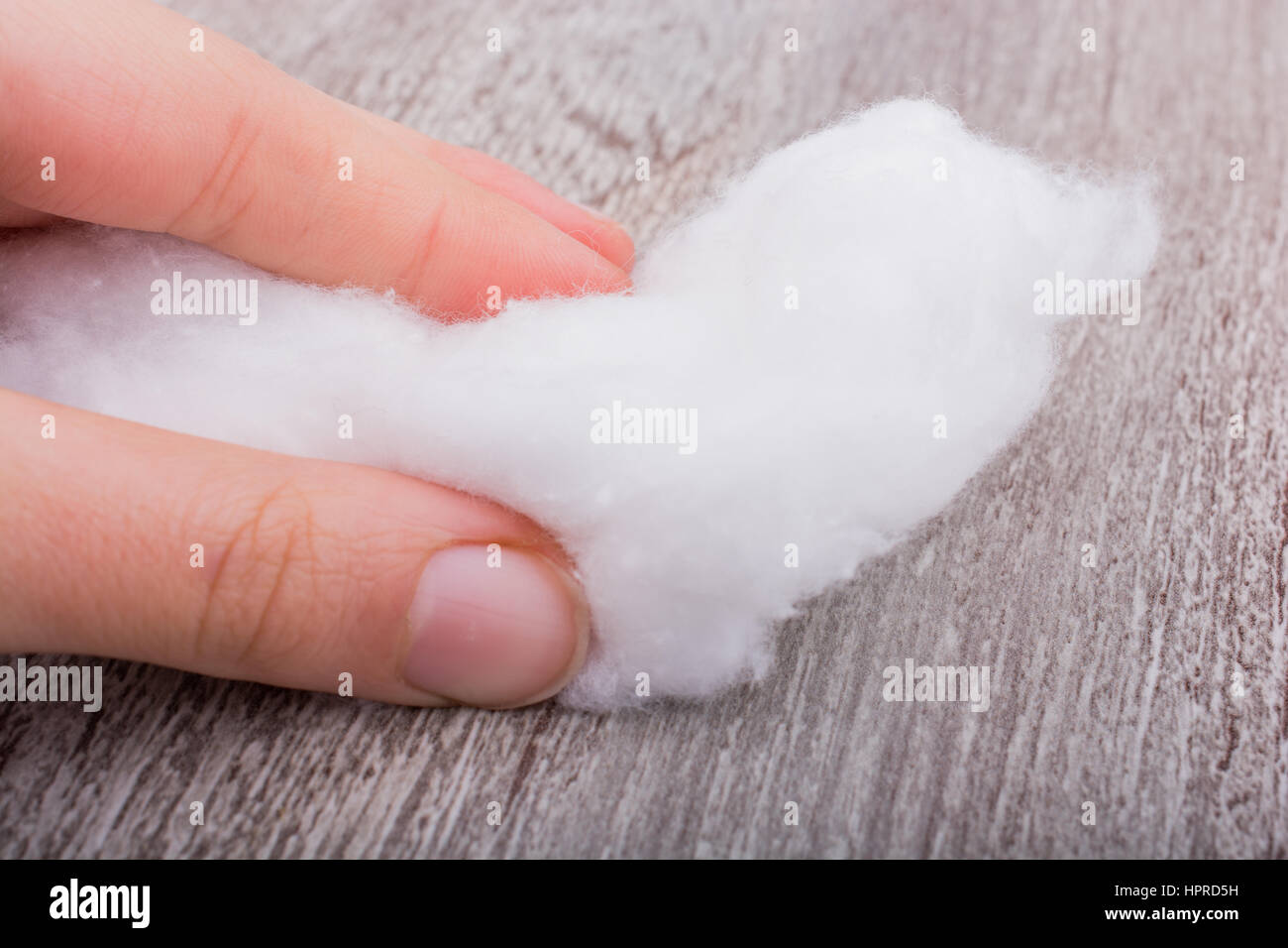 Hand holding some cotton in hand on a grey background Stock Photo - Alamy