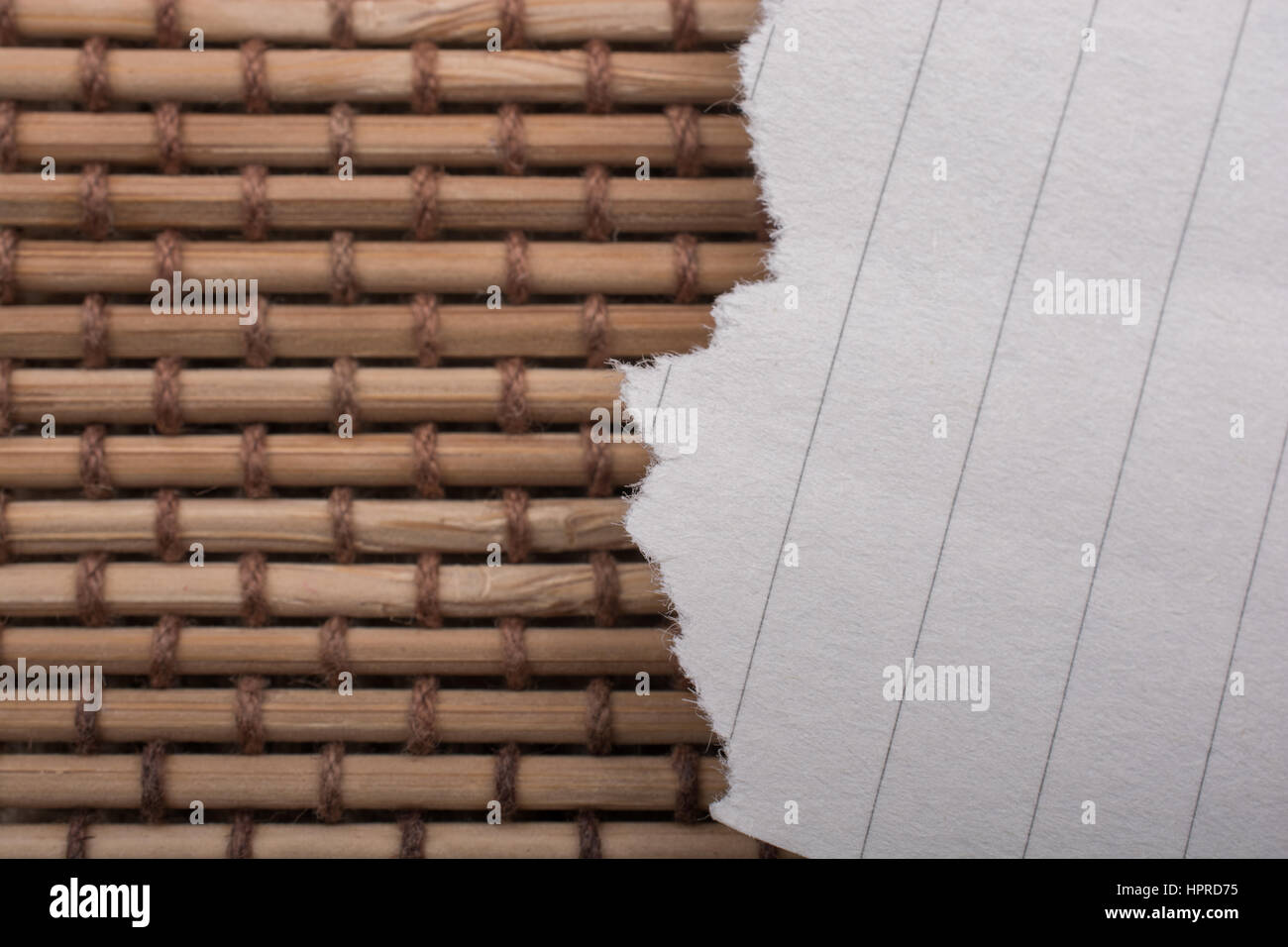 Piece of torn paper on a straw background Stock Photo - Alamy