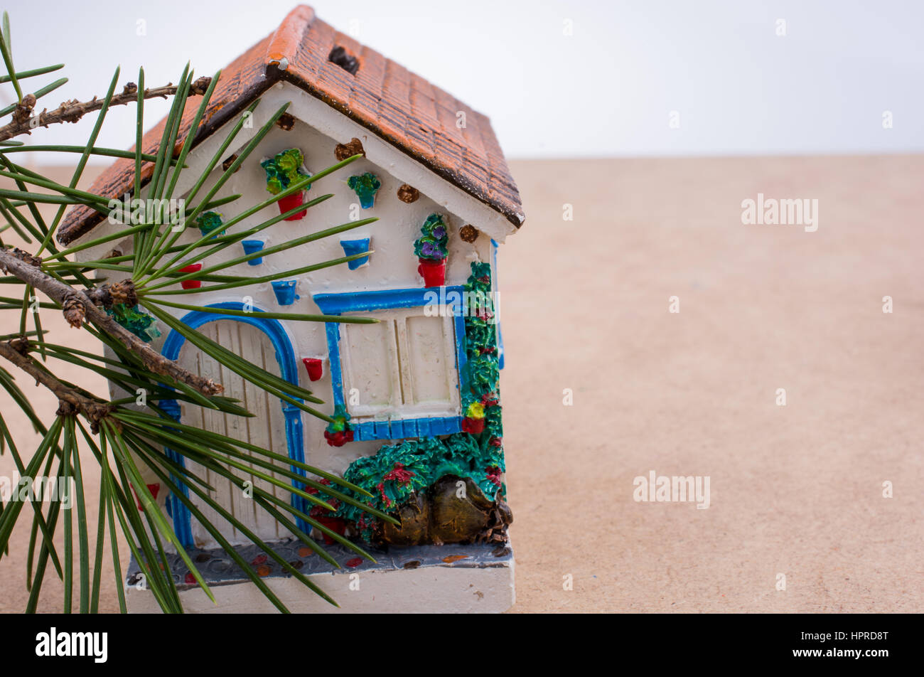 Little model house on a light brown color background Stock Photo - Alamy