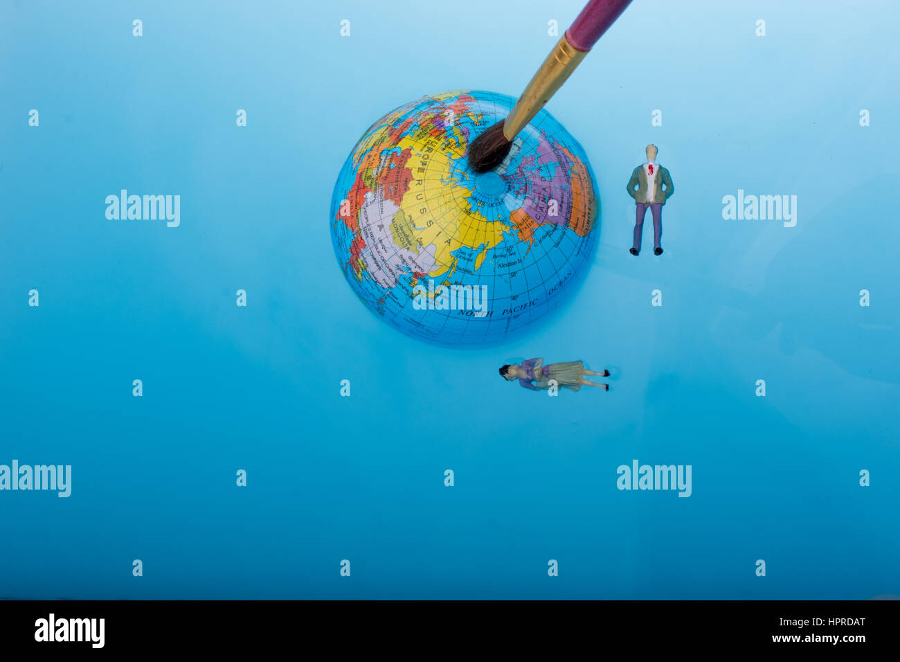 Brush and little globe with floating figurines around in water Stock ...