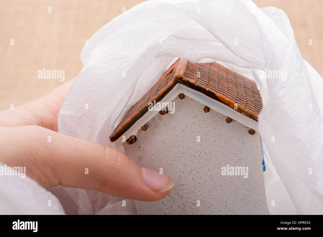 Little model house wrapped in cloth on a brown background Stock Photo ...