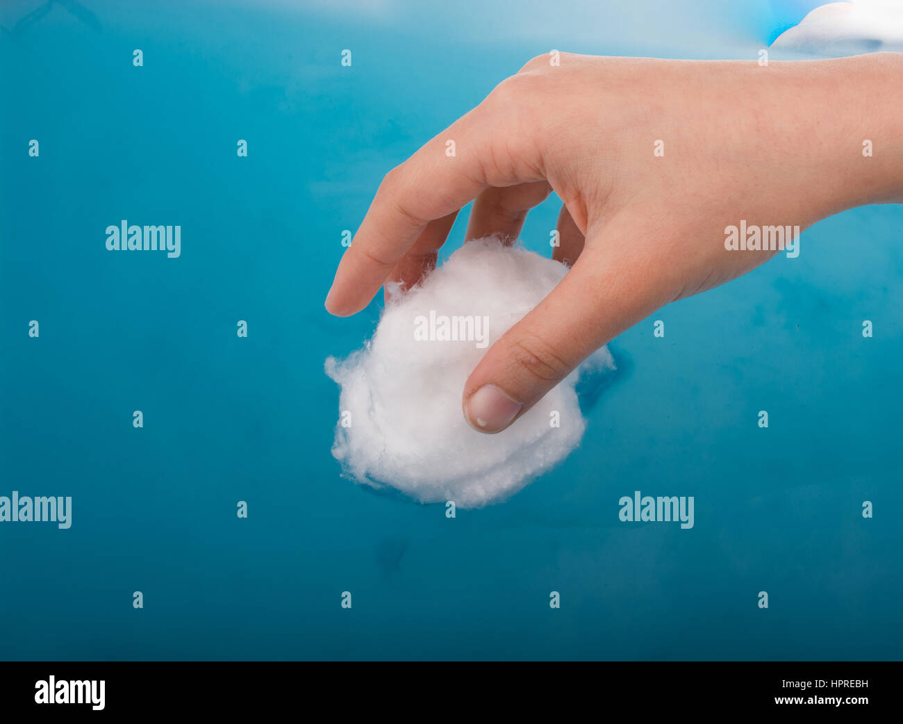 Hand holding some cotton in blue water Stock Photo - Alamy