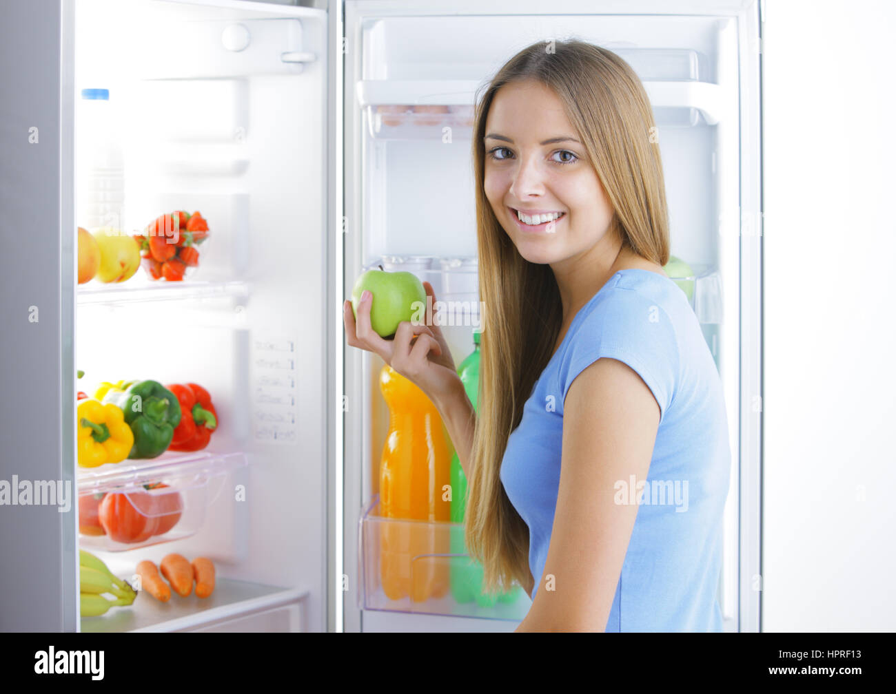 Young woman takes an apple Stock Photo - Alamy