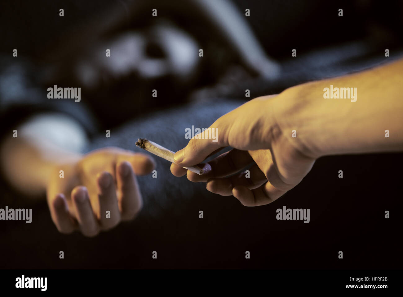 Close up of two young adults smoking a joint Stock Photo - Alamy