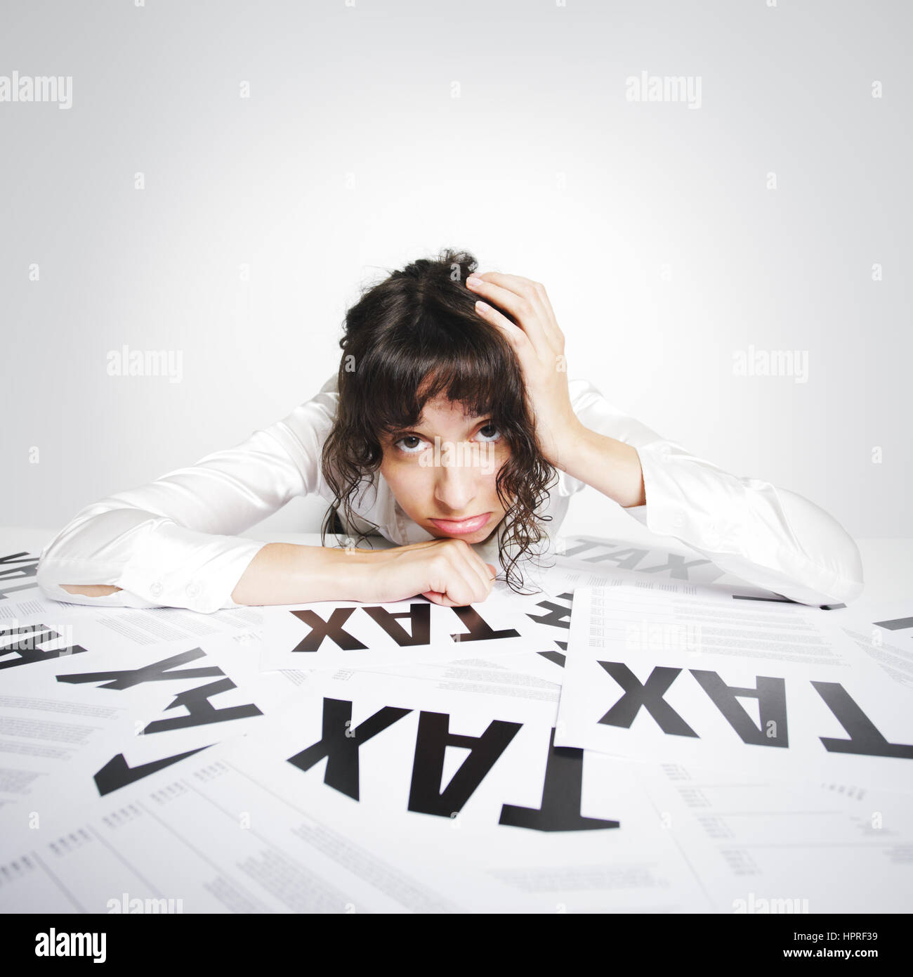 Sad woman on her taxes-paperwork covered desk desperately looking at ...