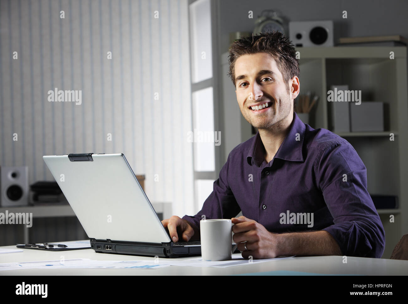 Man working on laptop looking at camera hi-res stock photography and ...