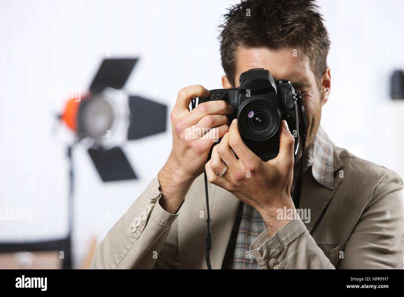 Young man taking photo with professional digital camera, focus on hand ...