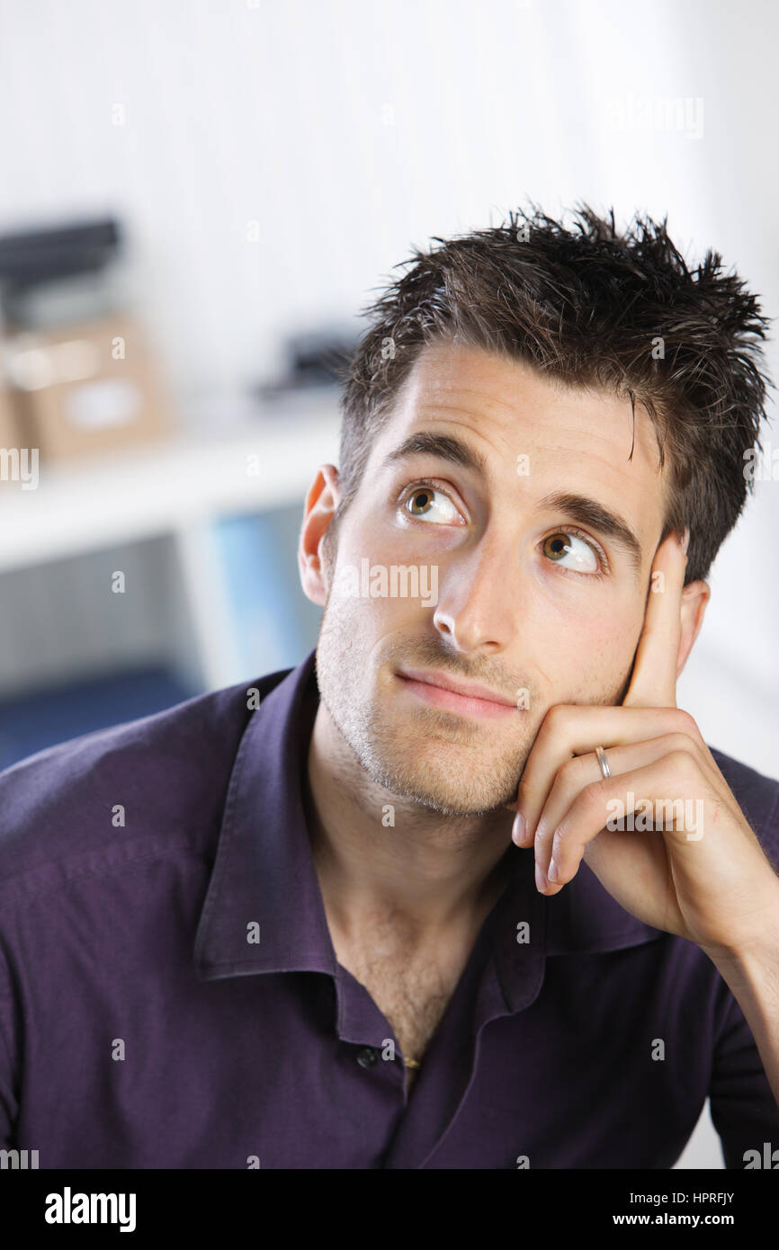 Portrait of a casual young man thinking Stock Photo - Alamy