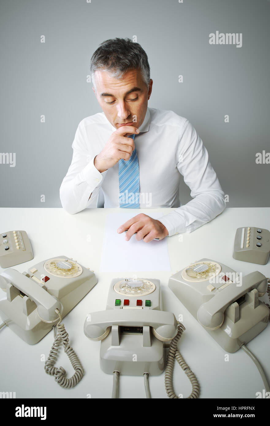 Mature business man with three phone waiting for a call Stock Photo - Alamy