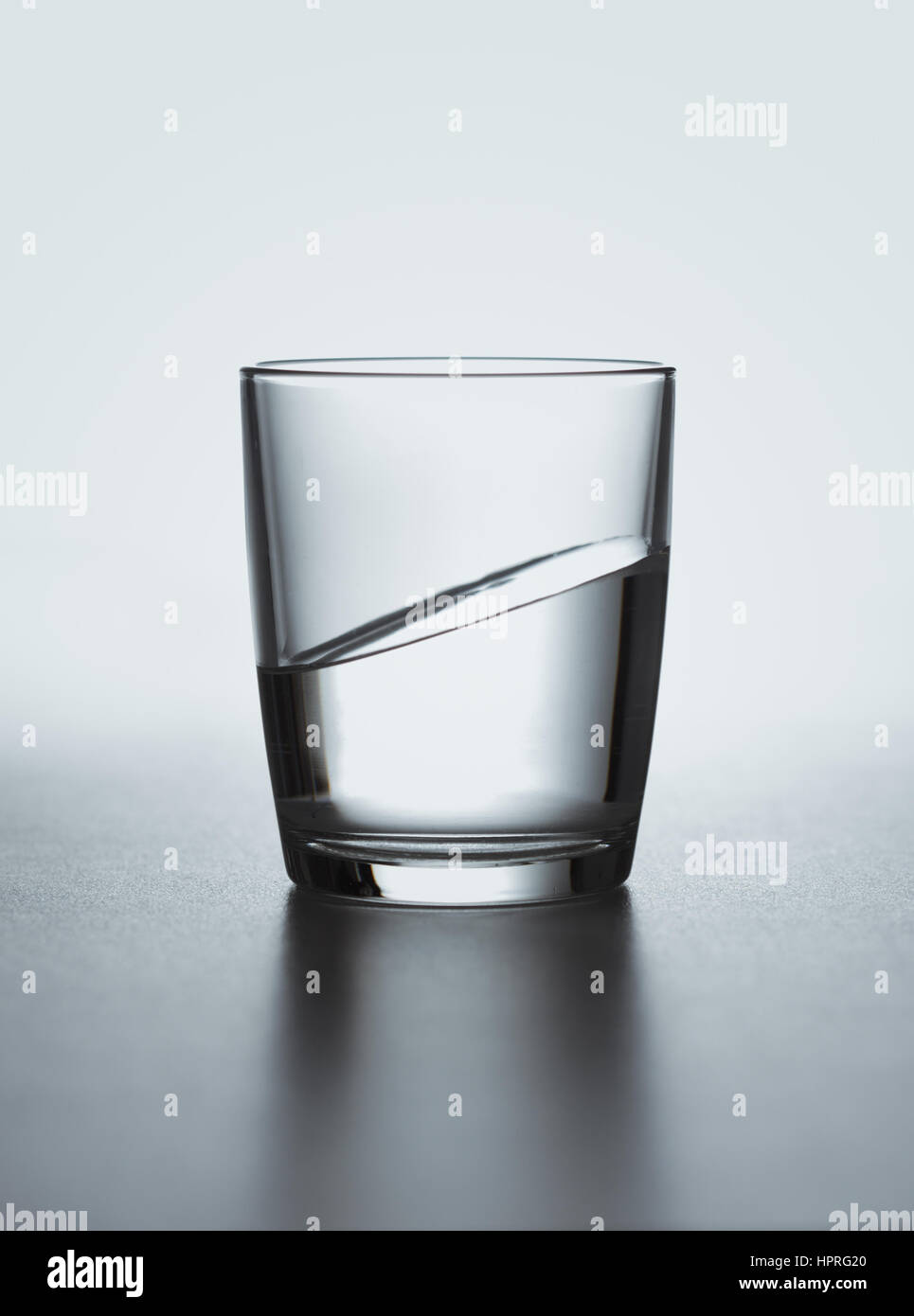 Glass of water, water level inclined Stock Photo - Alamy