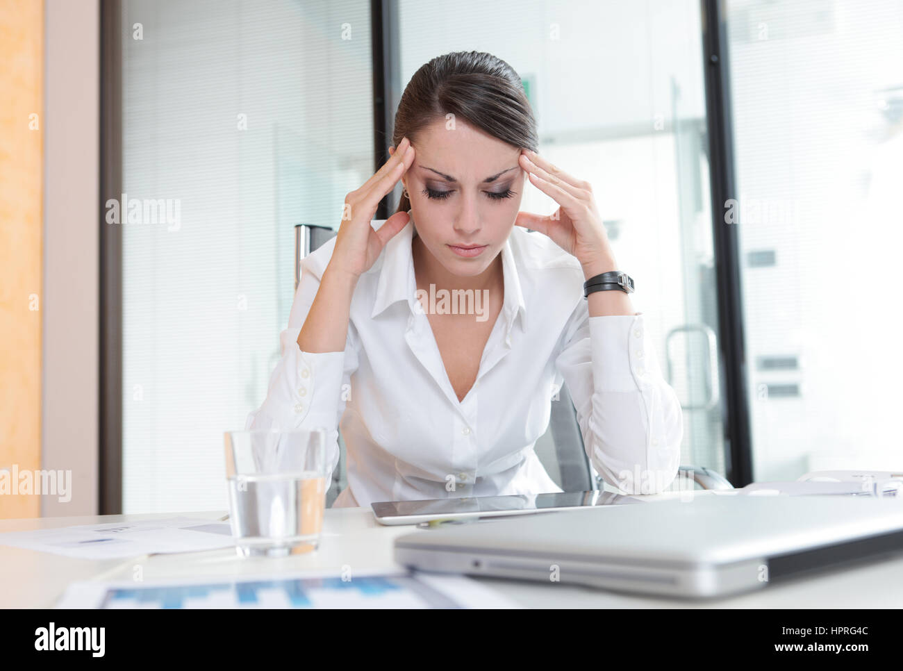 Overworking business woman suffering from headache Stock Photo - Alamy