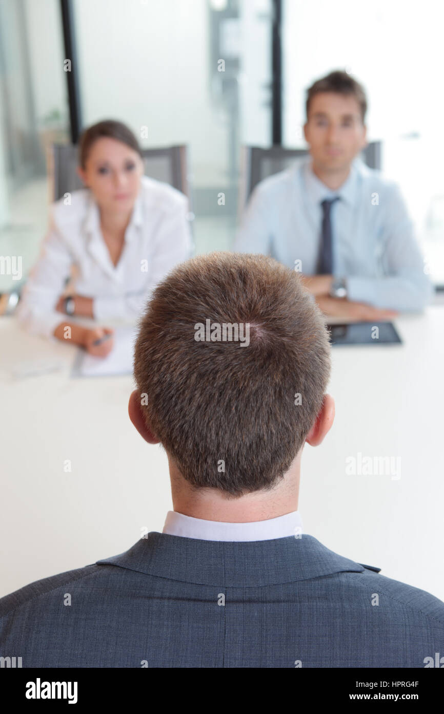 Two business people having job interview with young man Stock Photo - Alamy
