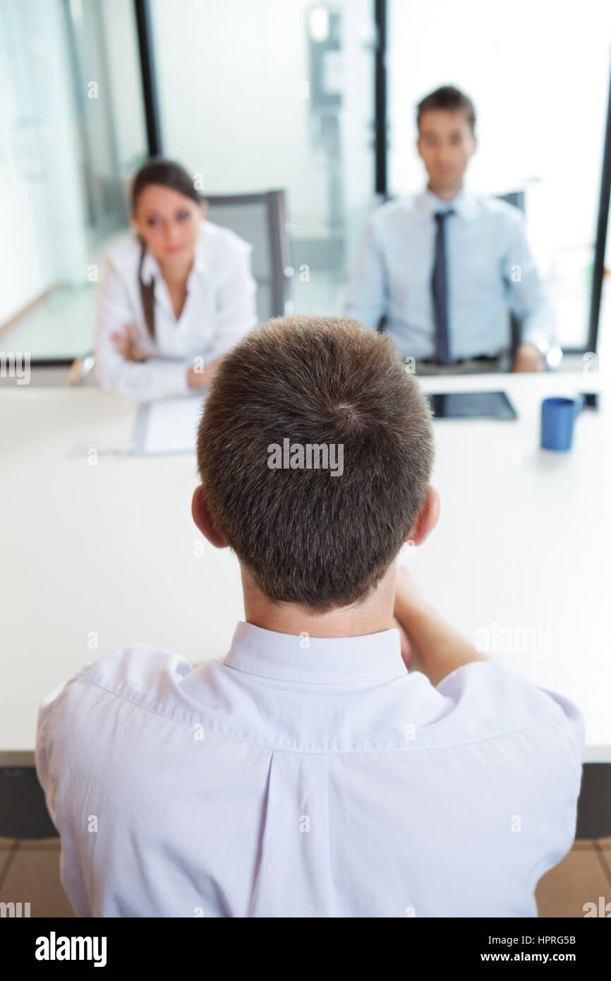 Two business people having job interview with young man Stock Photo - Alamy