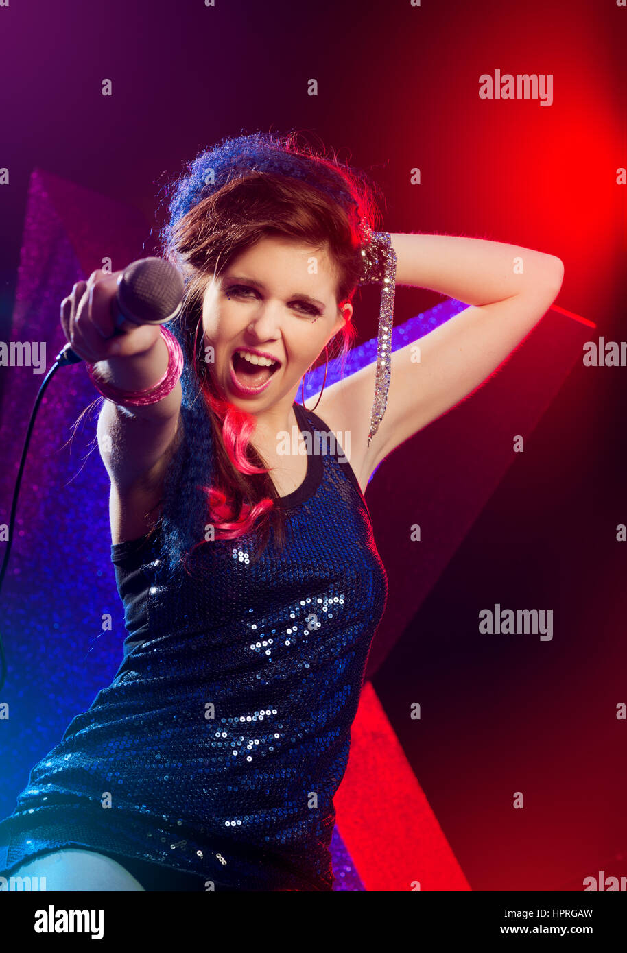 Young beautiful girl singing on stage with star on background Stock ...