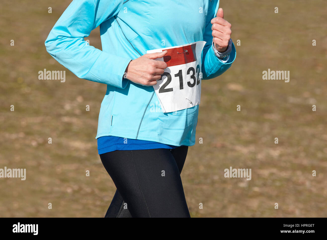 Female athletic runner on a cross country race. Outdoor circuit ...