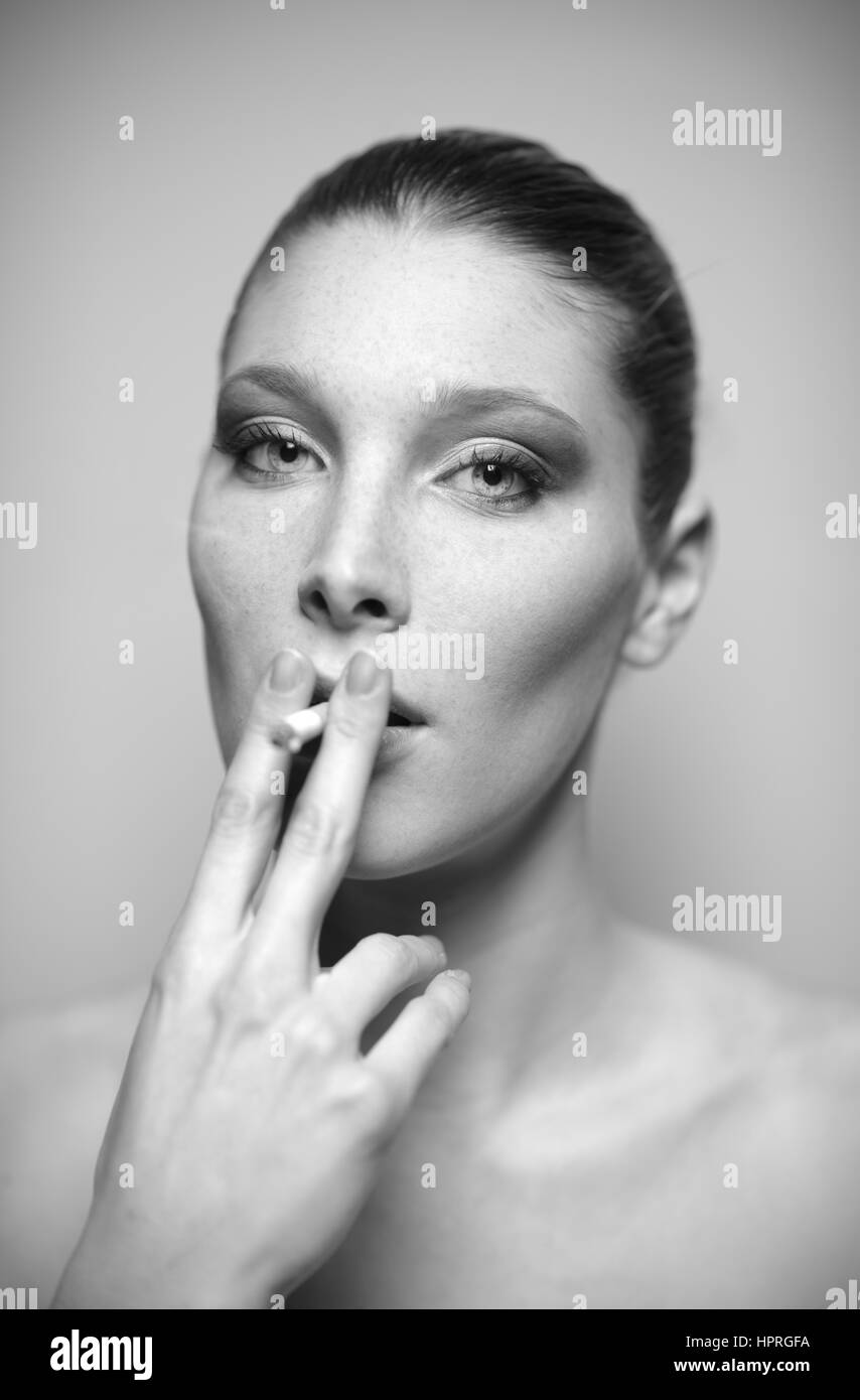 Portrait of beautiful young woman smoking a cigarette Stock Photo - Alamy