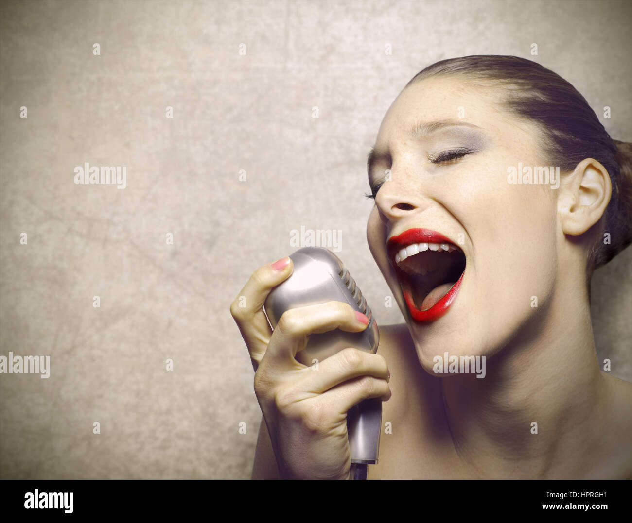 Beautiful female singer with vintage microphone Stock Photo - Alamy