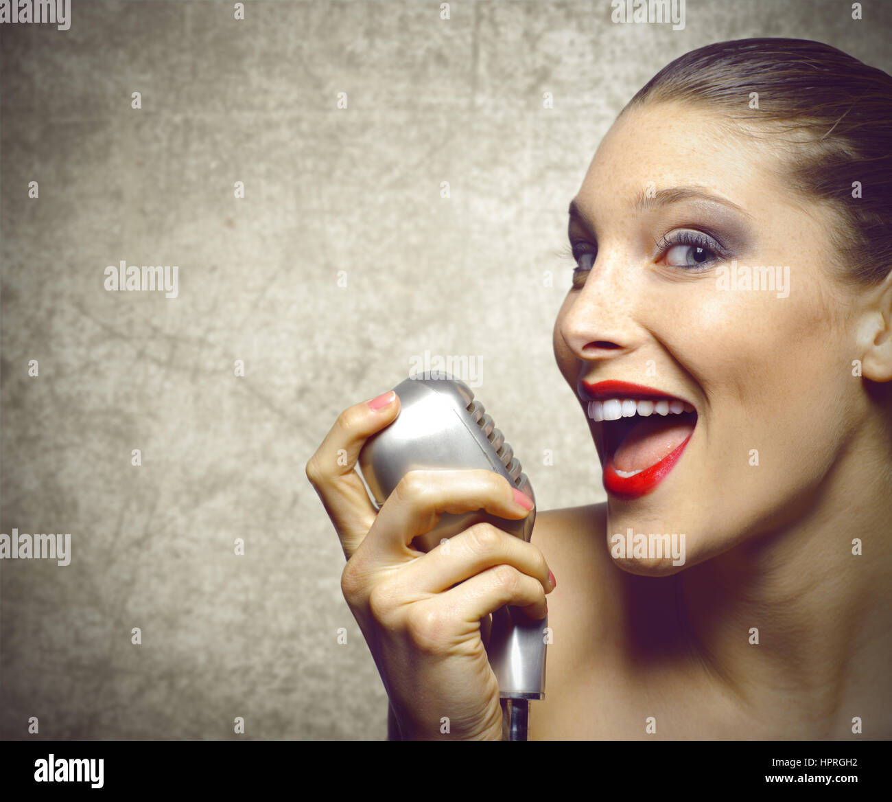 Beautiful female singer with vintage microphone Stock Photo - Alamy